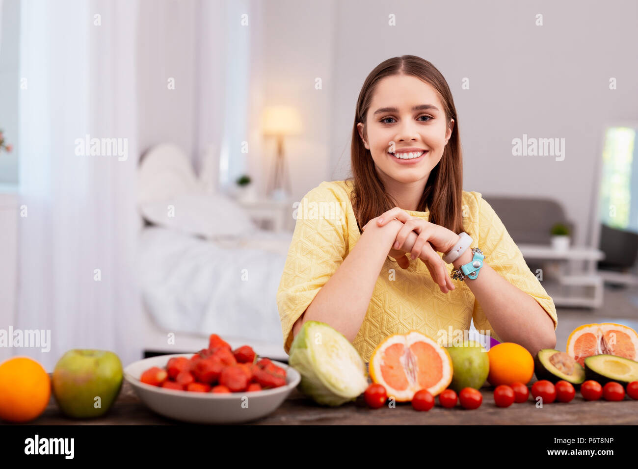 Optimistic teen girl eating fruit Stock Photo - Alamy
