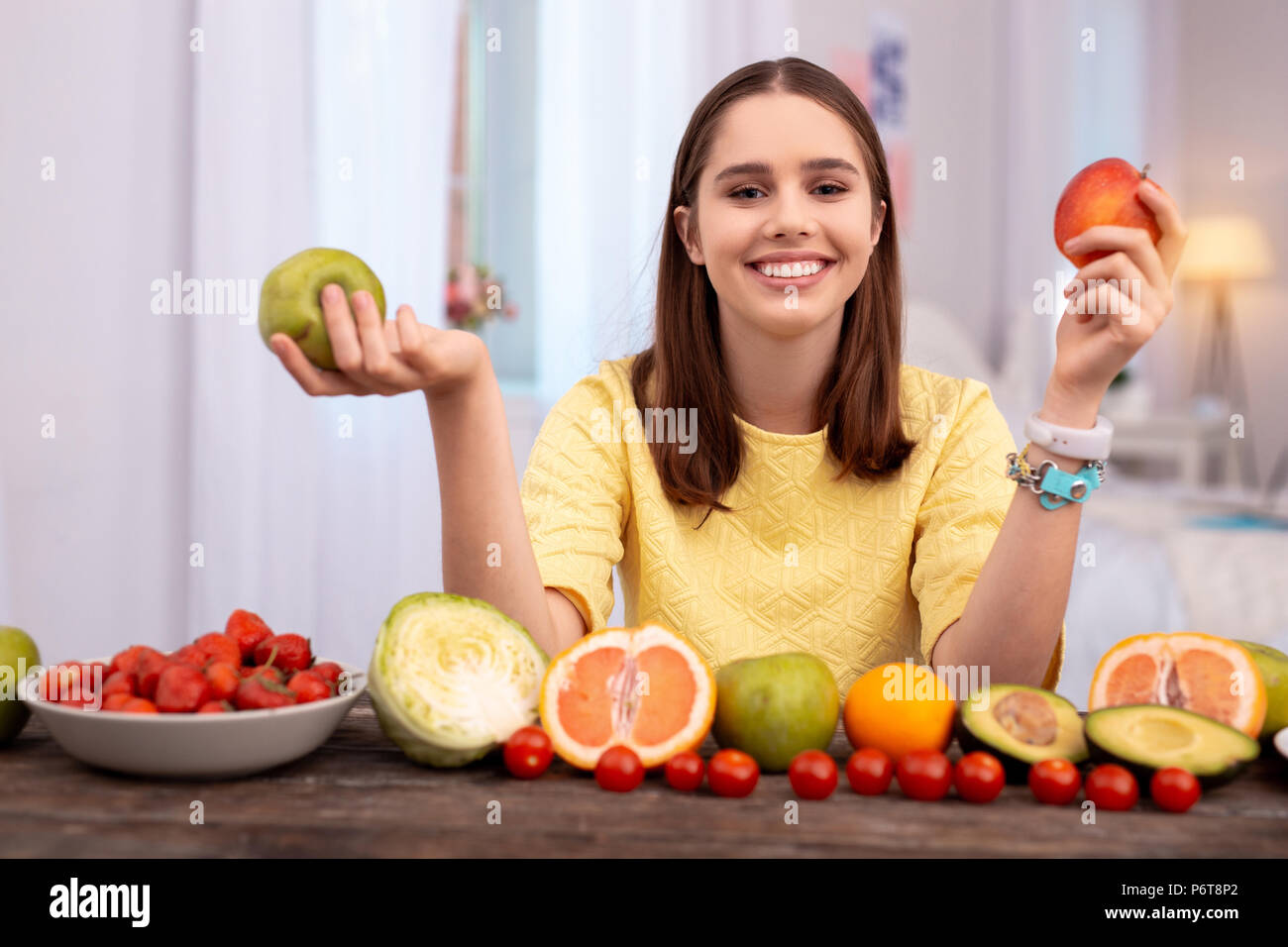 Joyful teen girl choosing fruit Stock Photo - Alamy