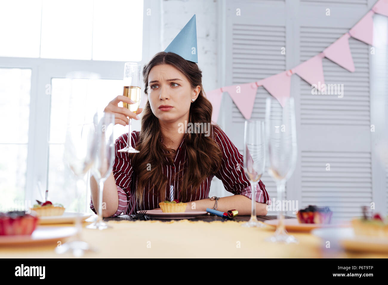 Woman feeling pessimistic at birthday party Stock Photo - Alamy
