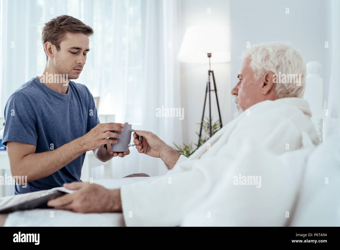 Upset man caring about senior man Stock Photo - Alamy