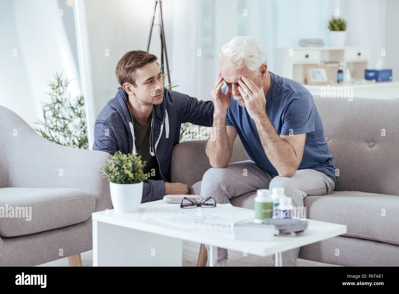 Man soothing unhappy senior man Stock Photo - Alamy