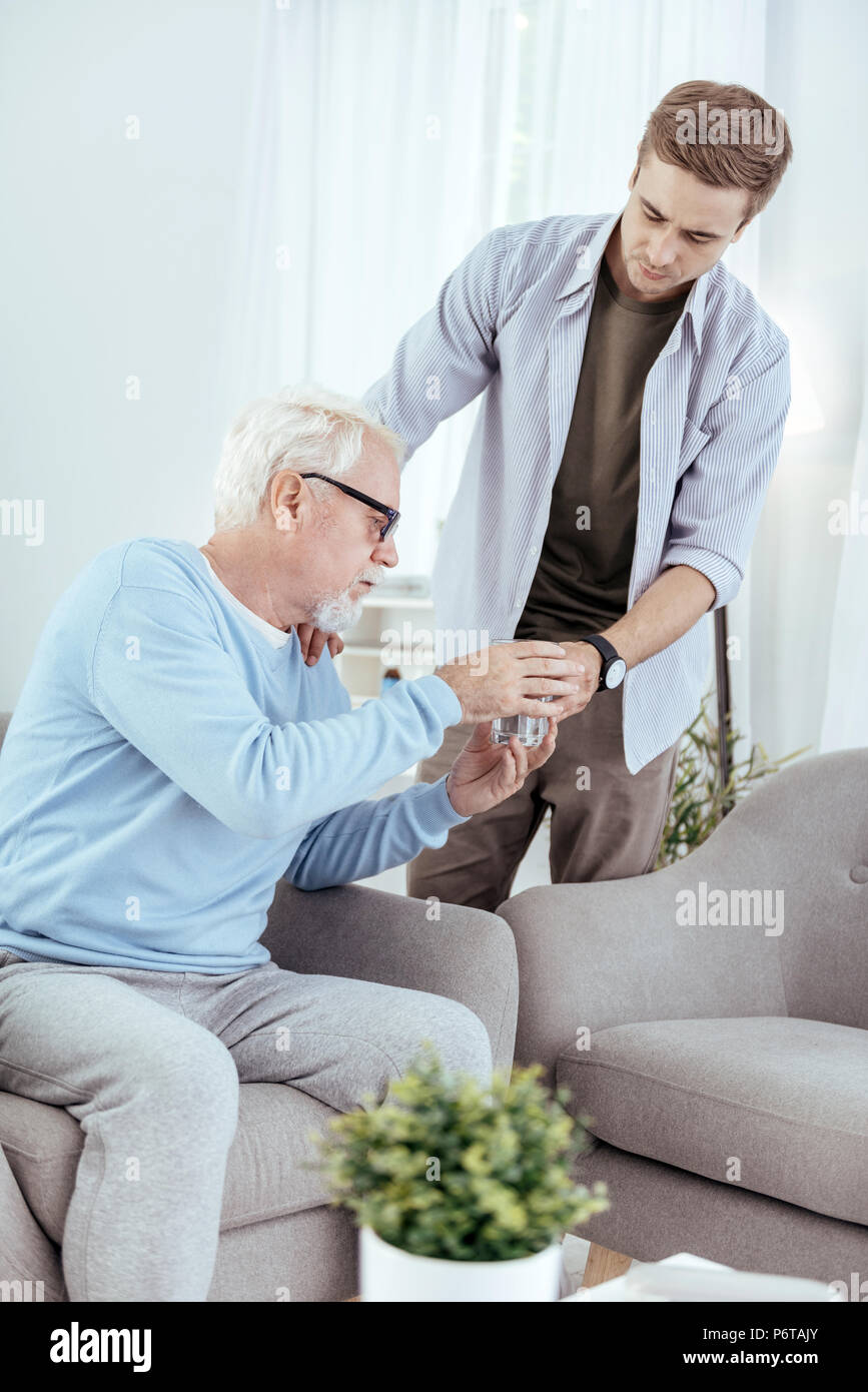 Confident senior man receiving water Stock Photo - Alamy