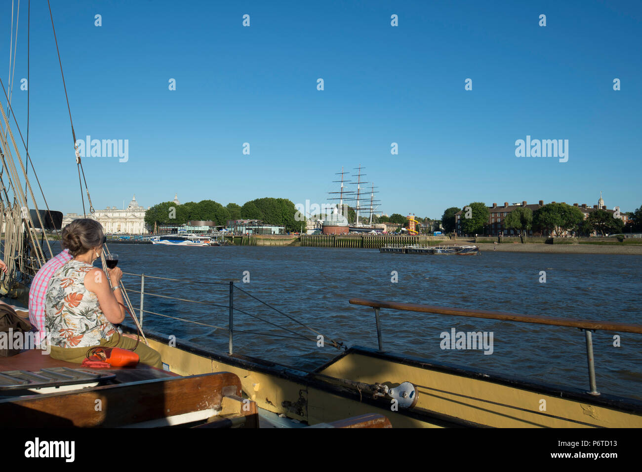 Tourist taking in the view of the Cutty Sark from a sailing barge on ...