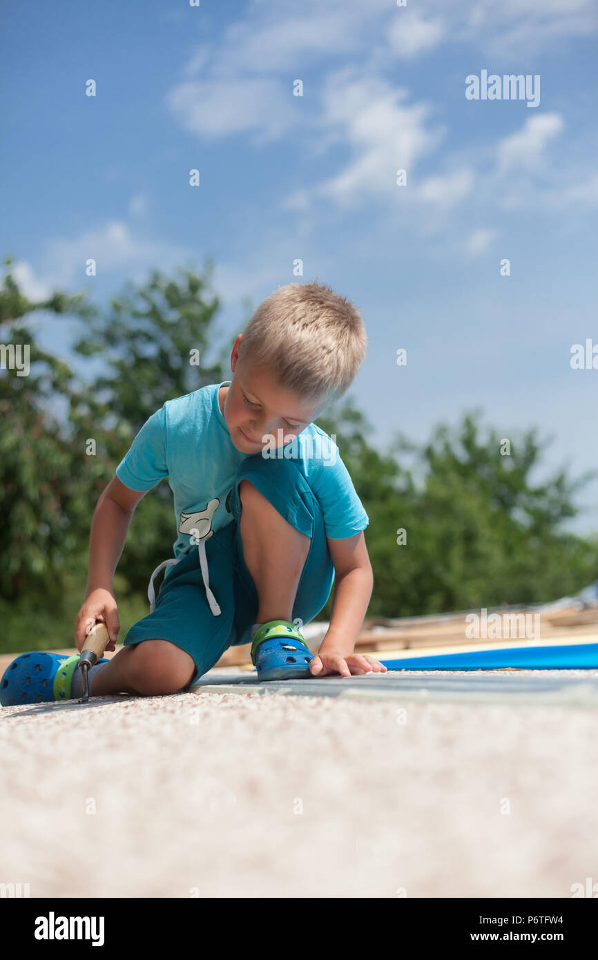 A little boy is working on a new pavement around the pool Stock Photo ...