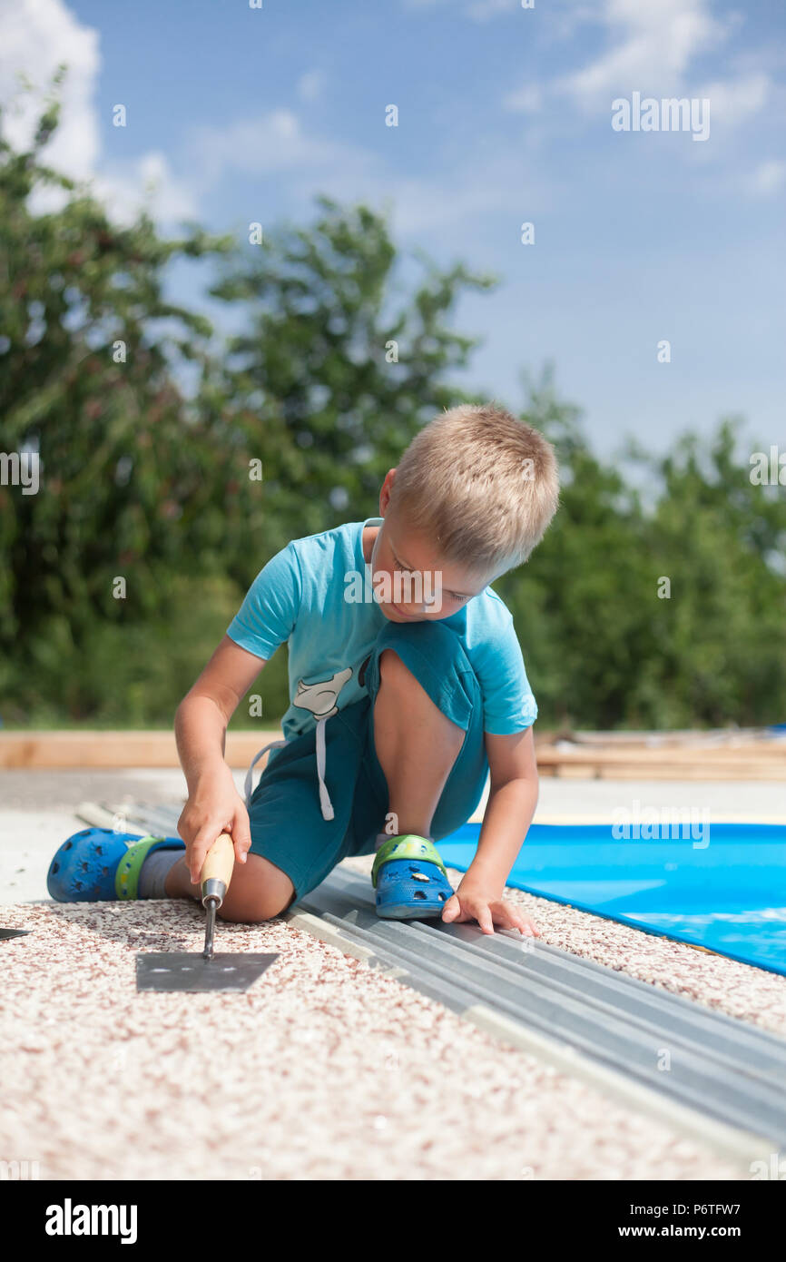 A little boy is working on a new pavement around the pool Stock Photo ...