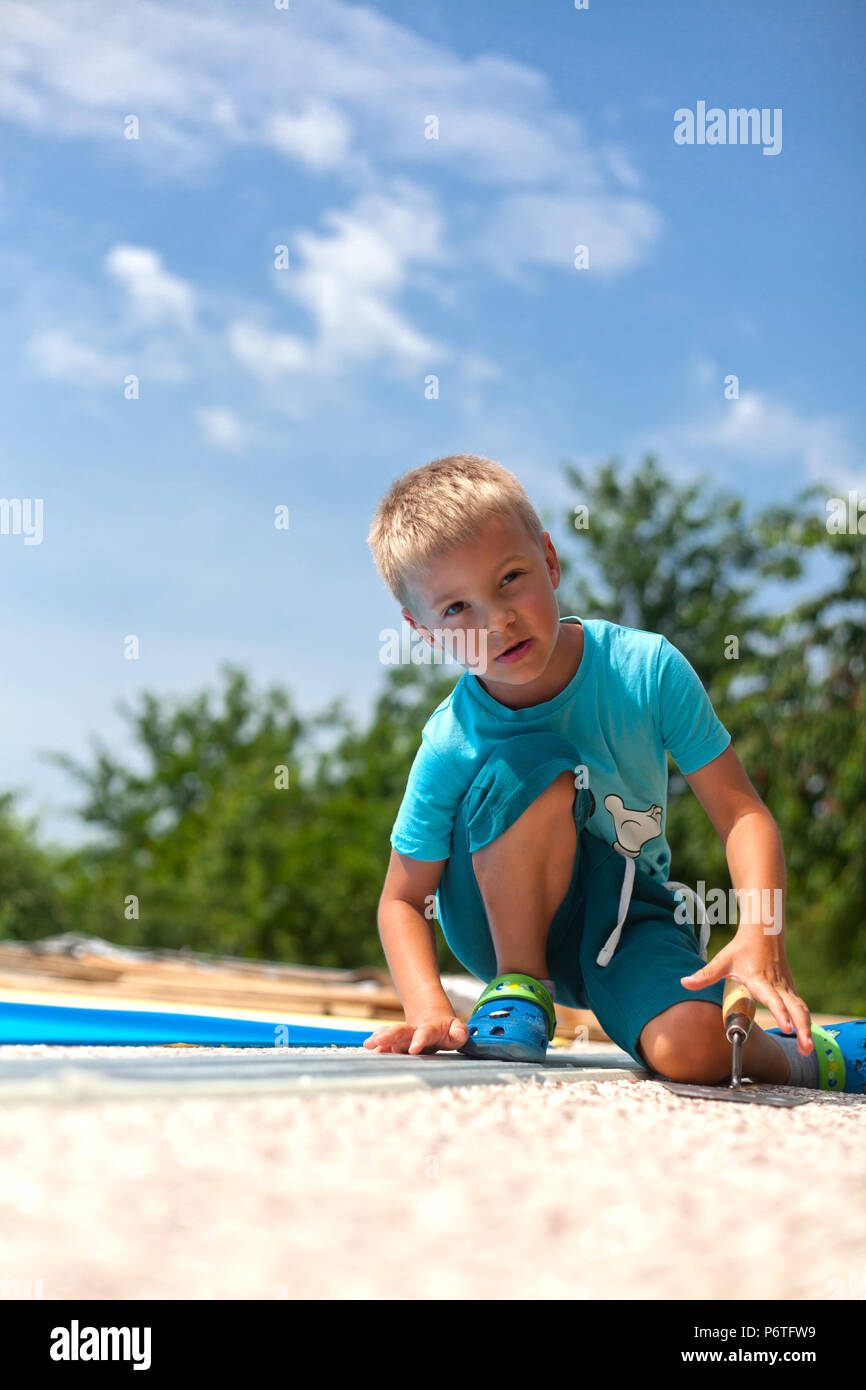 A little boy is working on a new pavement around the pool Stock Photo ...