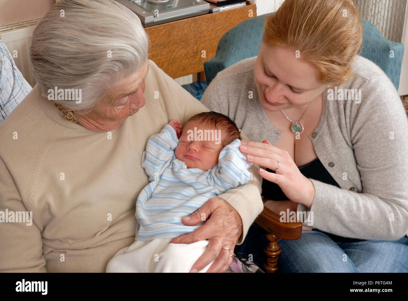 Newborn baby being held and cuddled by his grandmother Stock Photo - Alamy