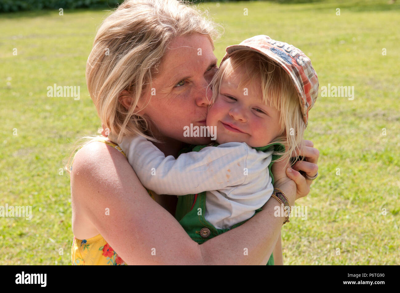 Mother cuddling her little boy outside Stock Photo - Alamy