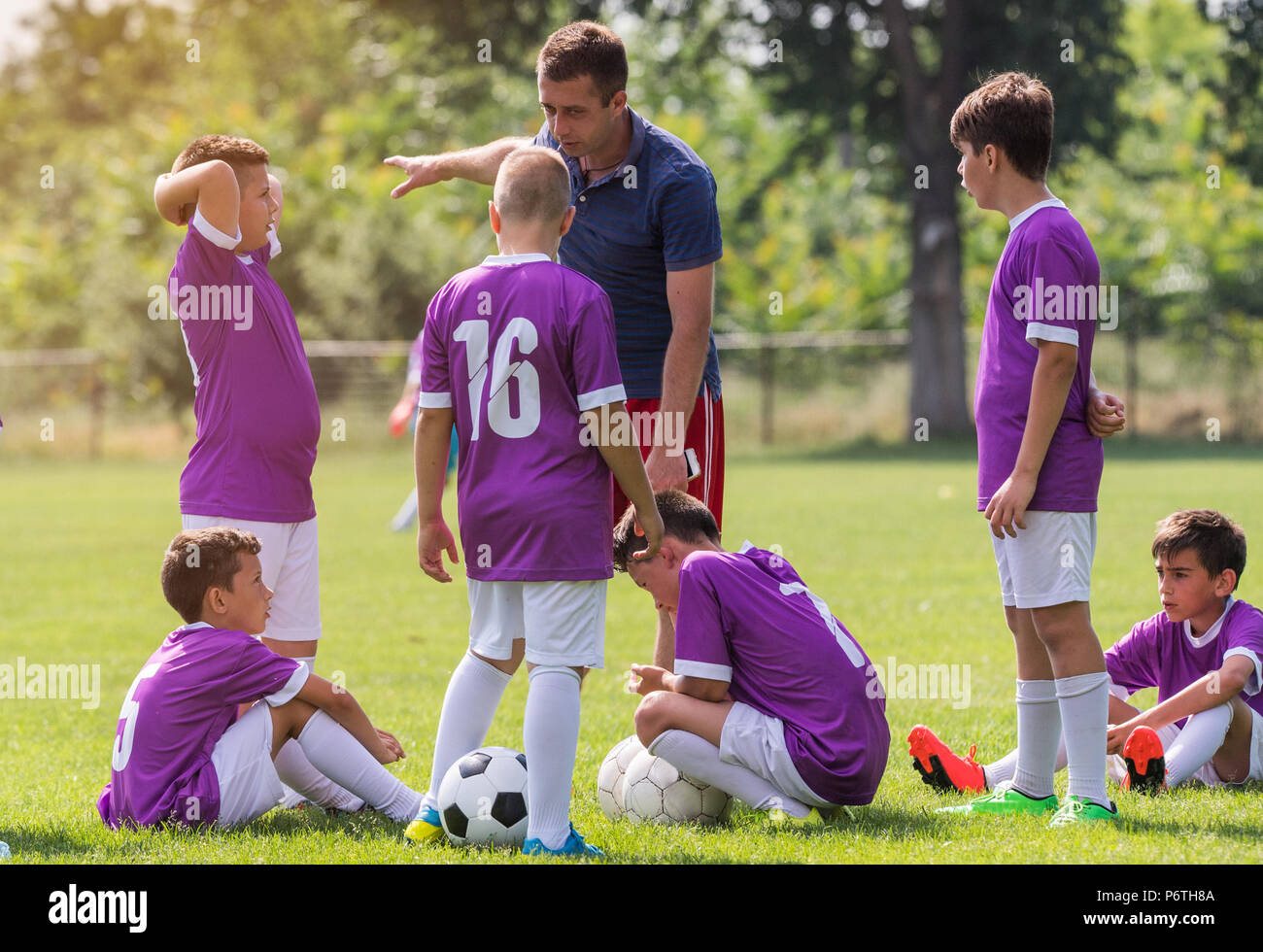 Coach is giving advice to young soccer players on football match Stock ...