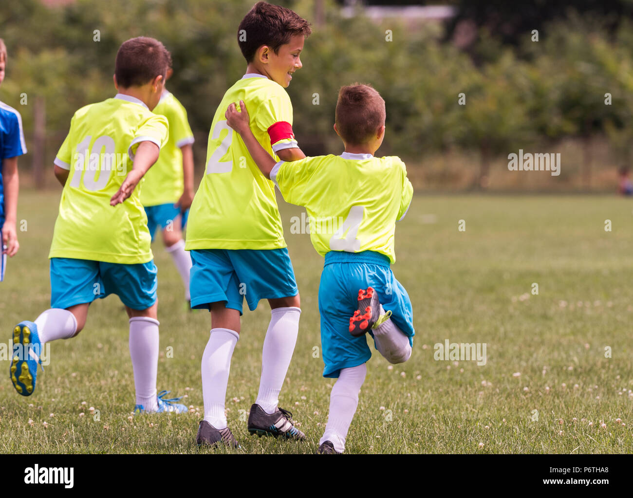 Kids soccer football - young children players celebrating in hug after ...