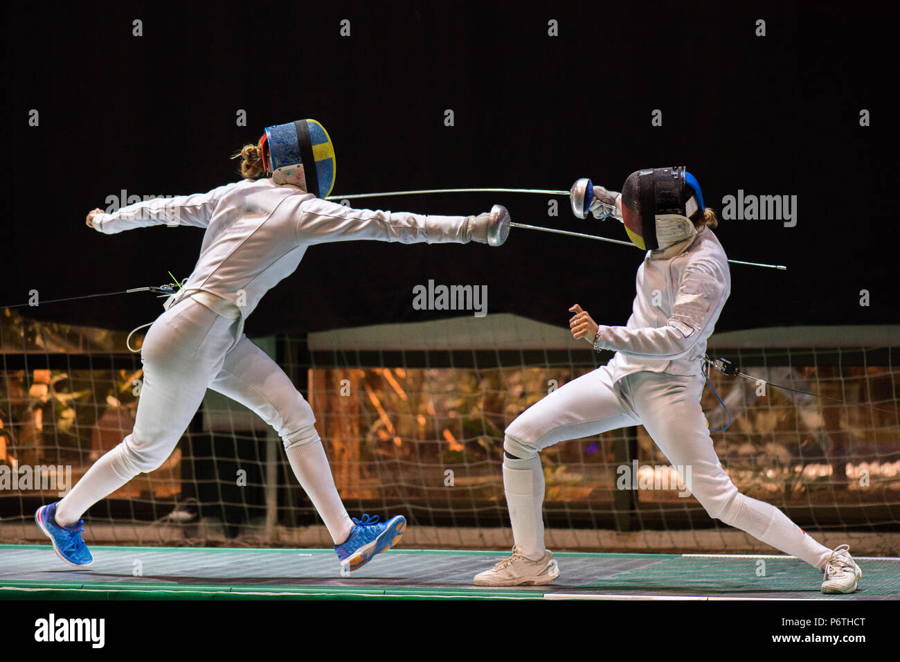Two woman fencing athletes fight on professional sports arena Stock ...