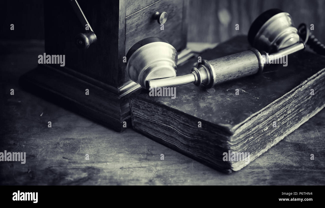 Old telephone and retro book on the desk. The phone of the past on an ...