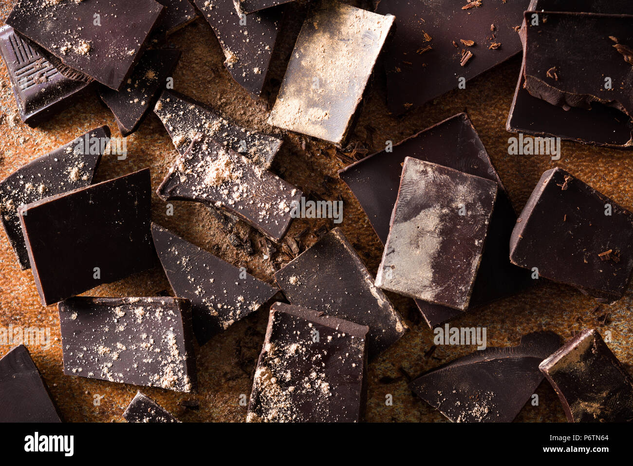 Broken chocolate pieces on brown background Stock Photo - Alamy