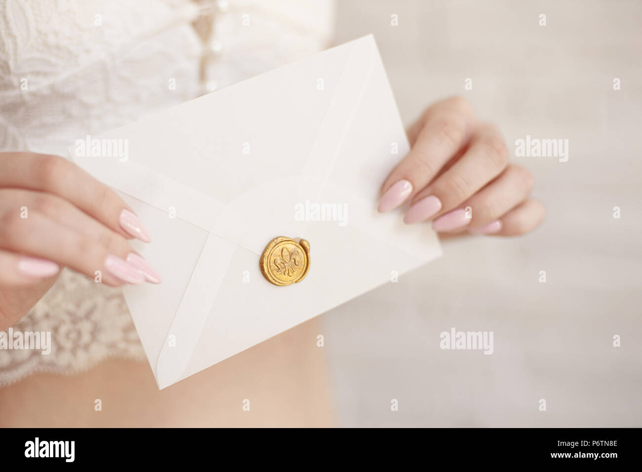 close-up woman with slim body holding invitation envelope card in hands ...