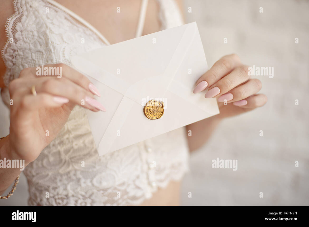 close-up woman with slim body holding invitation envelope card in hands ...