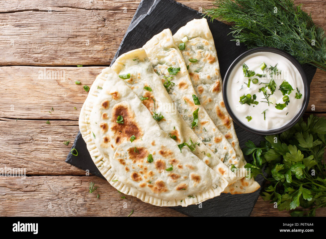 Azerbaijani food: flatbread qutab with greens and yogurt close-up on ...