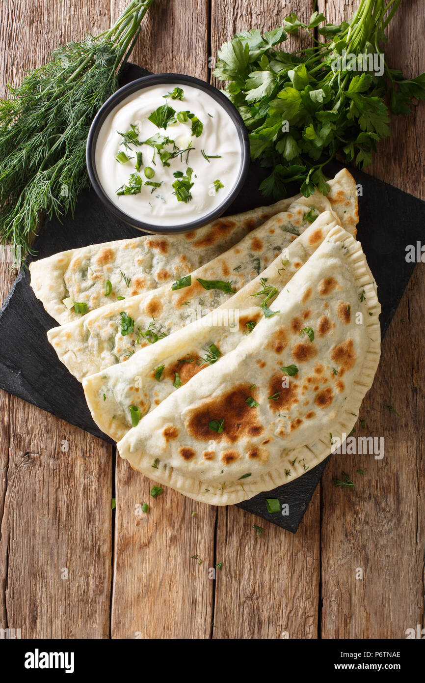 Azerbaijani food: flatbread qutab with greens and yogurt close-up on ...