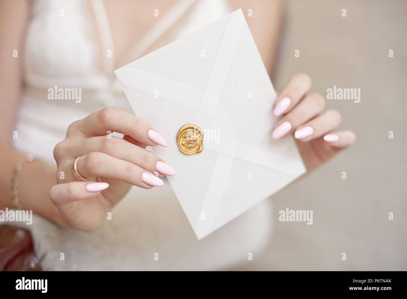 close-up woman with slim body holding invitation envelope card in hands ...