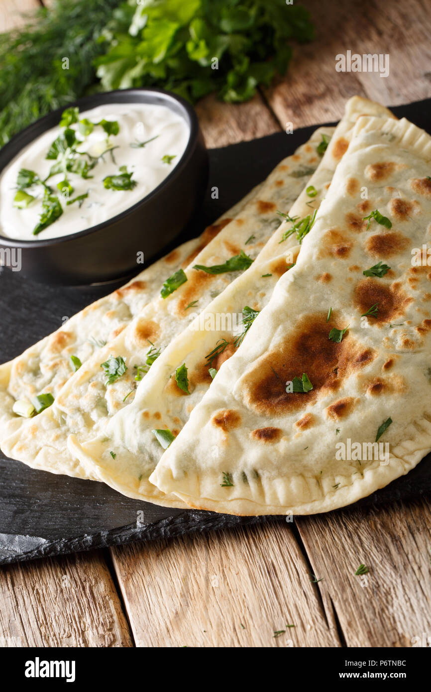 Azerbaijani food: flatbread qutab with greens and yogurt close-up on ...