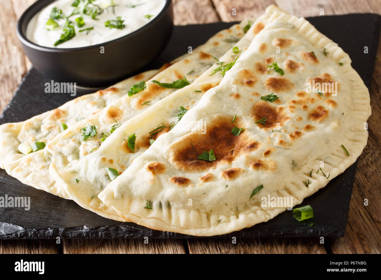 Azerbaijan flat bread qutab with greens close-up on the table ...