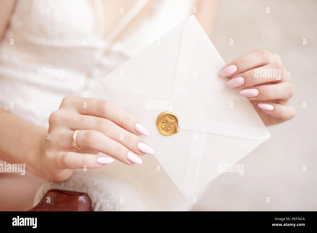 close-up woman with slim body holding invitation envelope card in hands ...
