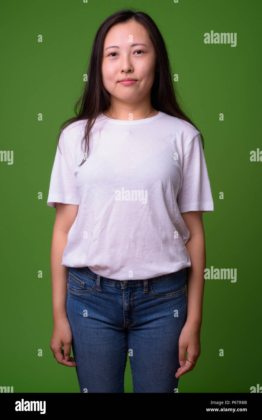 Young Chinese woman against green background Stock Photo - Alamy