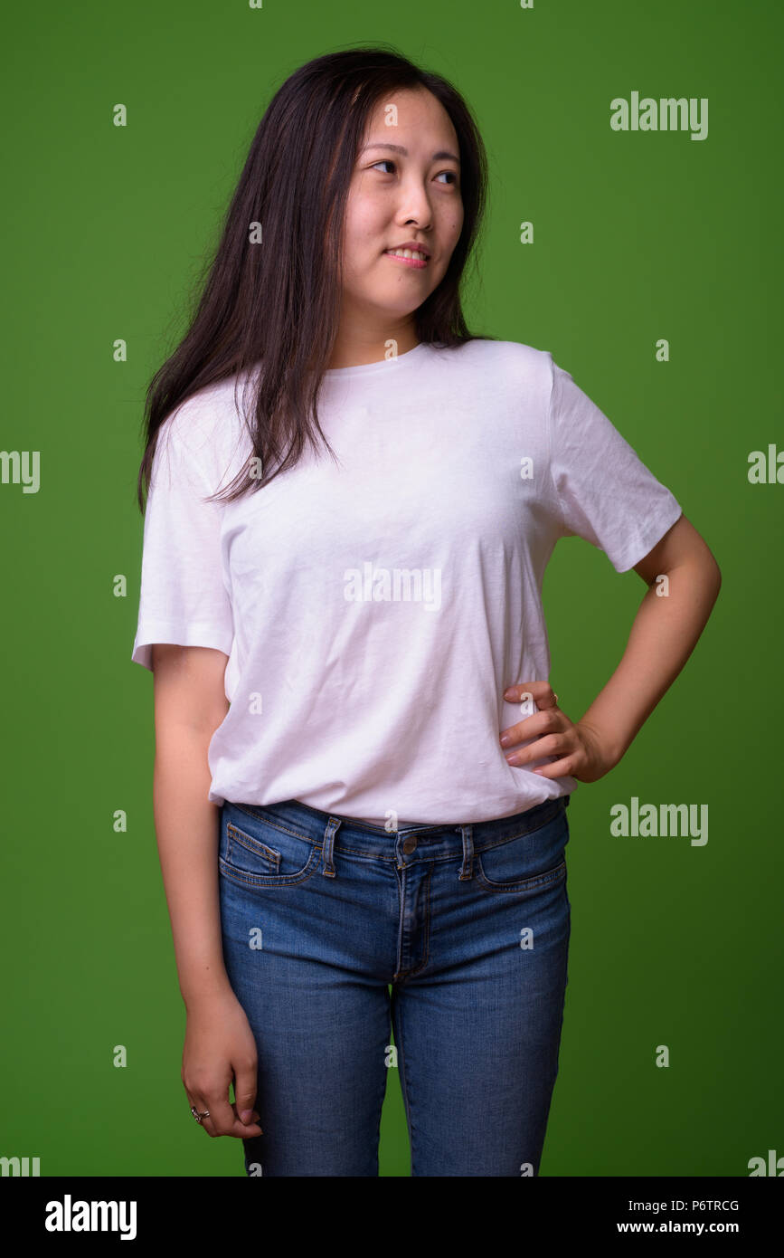 Young Chinese woman against green background Stock Photo - Alamy