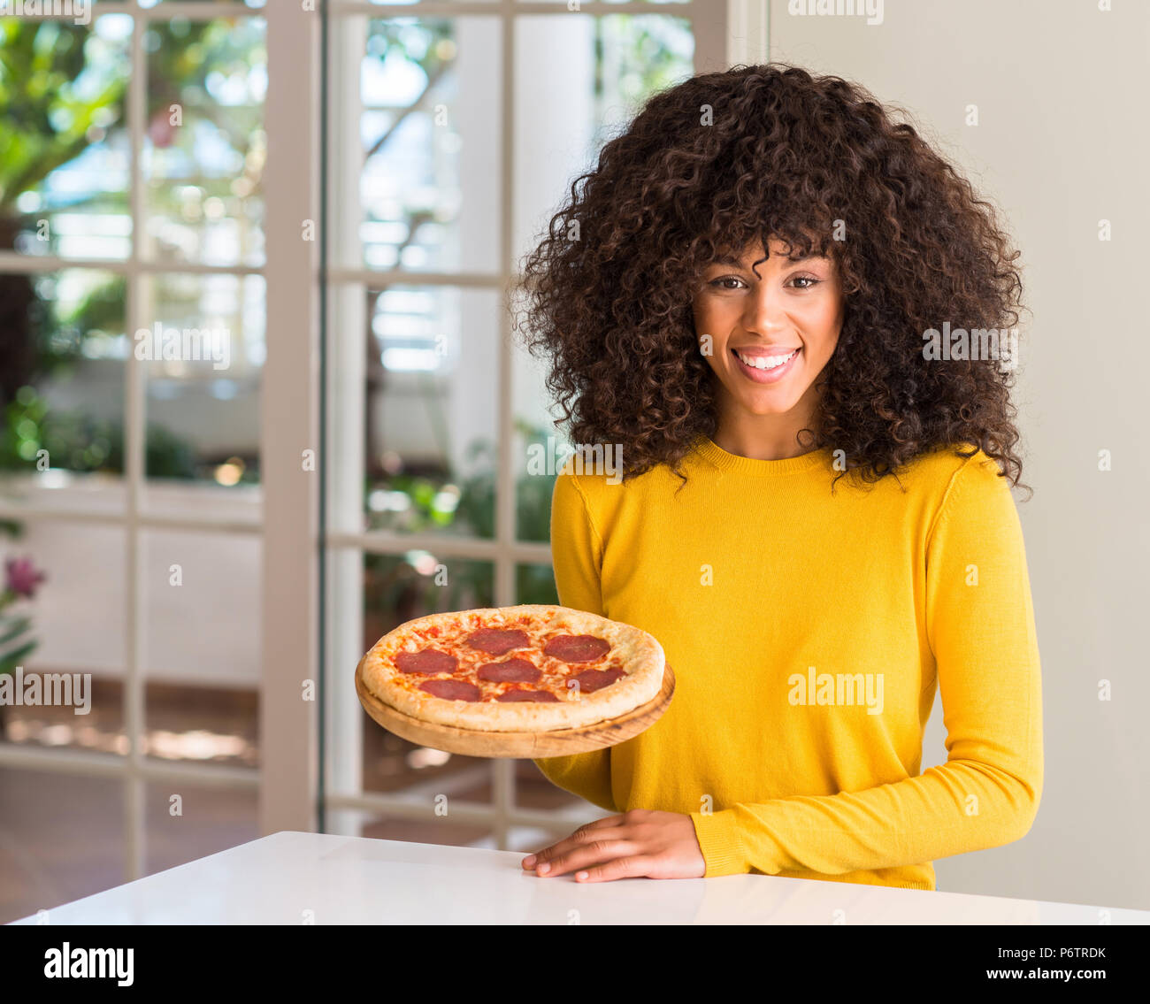 African american woman ready to eat tasty pepperoni pizza at home with ...