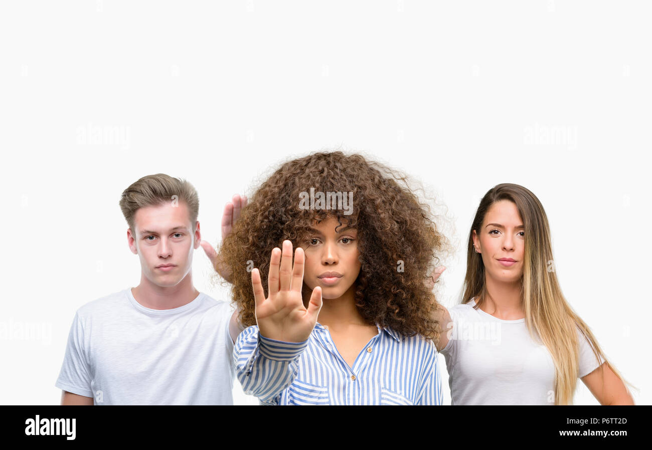 Group of young people over white background with open hand doing stop ...