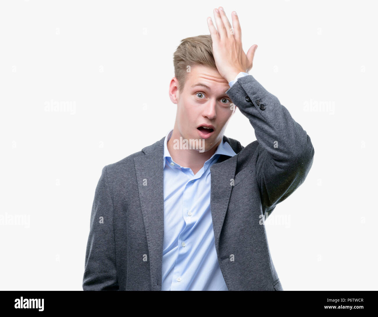 Young handsome blond business man surprised with hand on head for ...