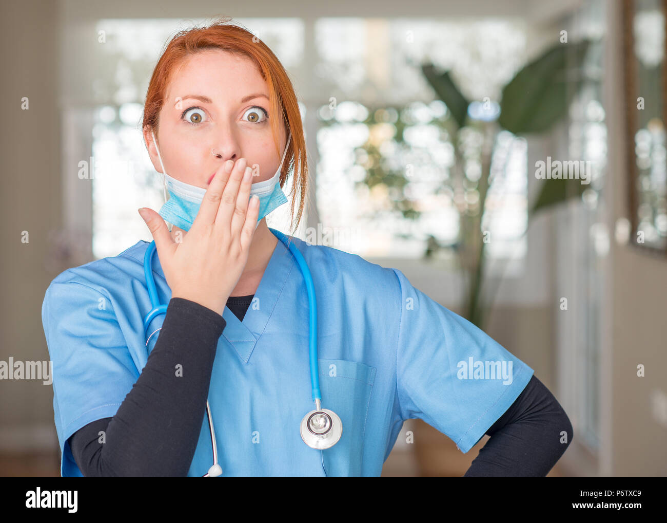 Medical professional woman with stethoscope cover mouth with hand ...