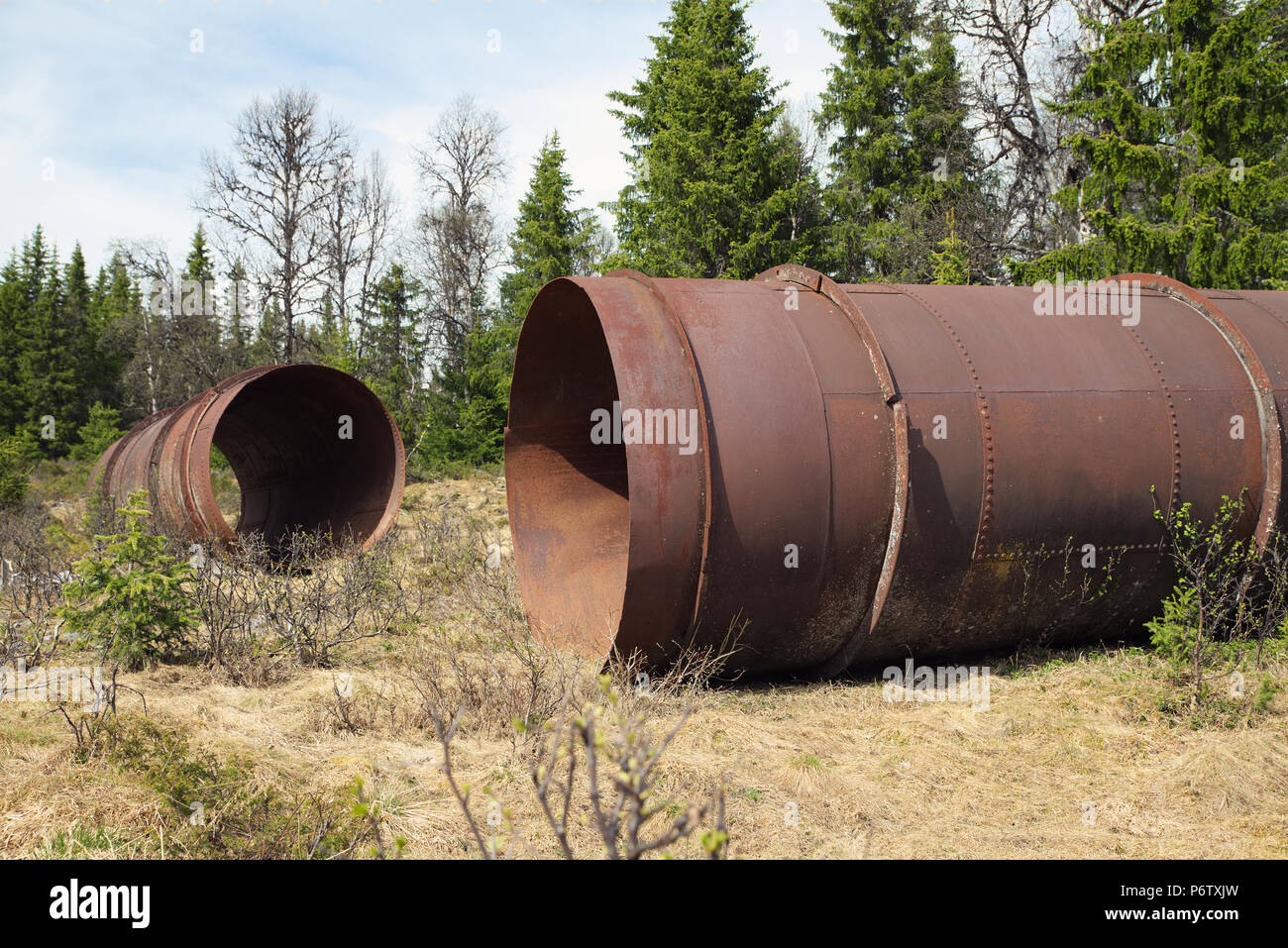 Two big old rusty metal cylinders left in the forest, Gol Norway.round ...