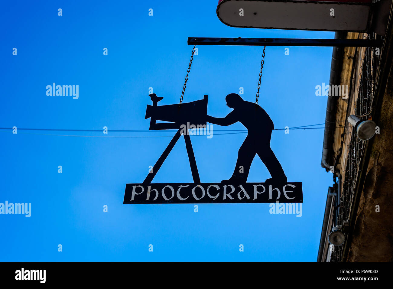 Old fashioned photography shop sign, silhouette of man looking into old ...