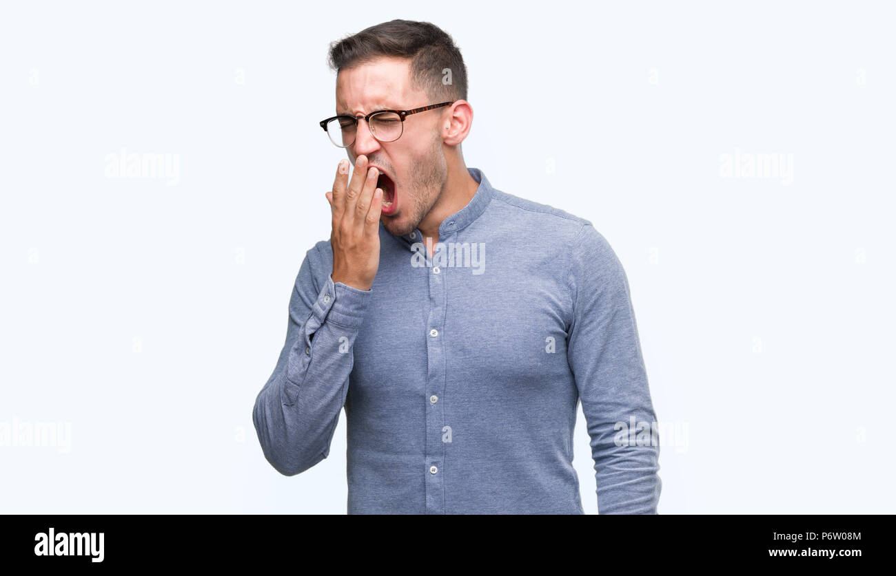 Handsome young elegant man wearing glasses bored yawning tired covering ...