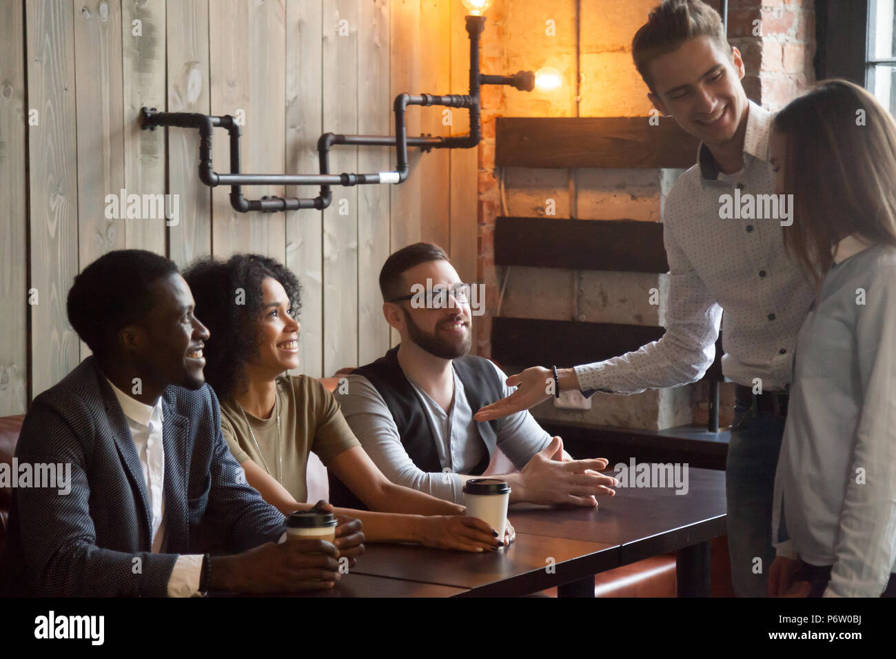 Smiling worker introducing new employee to colleagues during caf Stock ...