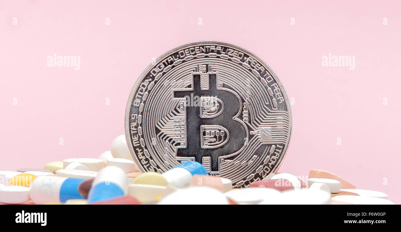 Bitcoin and pills on a pink background. Bitcoin as a medicine for the ...