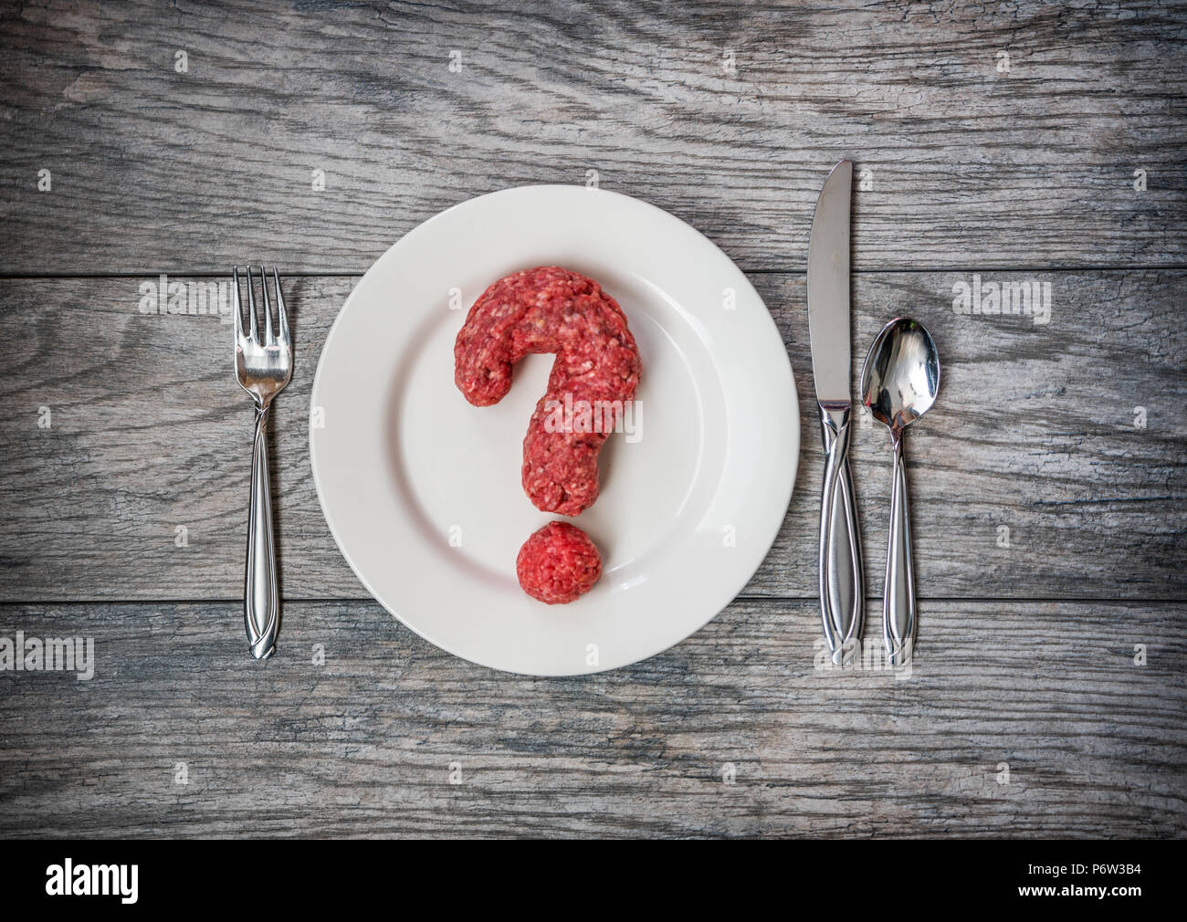 Meat shaped as a question mark on a plate Stock Photo - Alamy