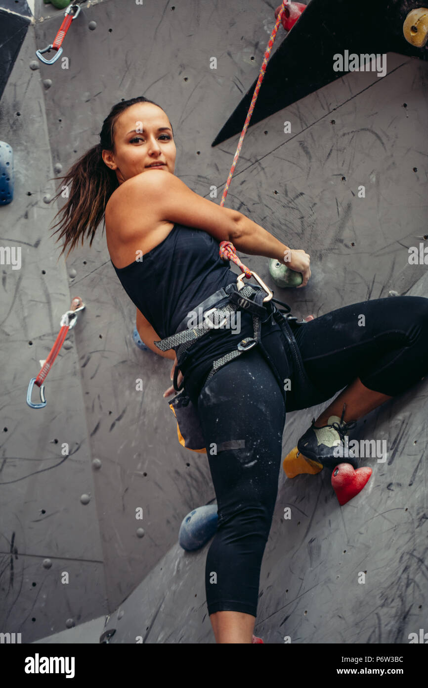 Close up of athletic female climber practicing rock climbing on ...