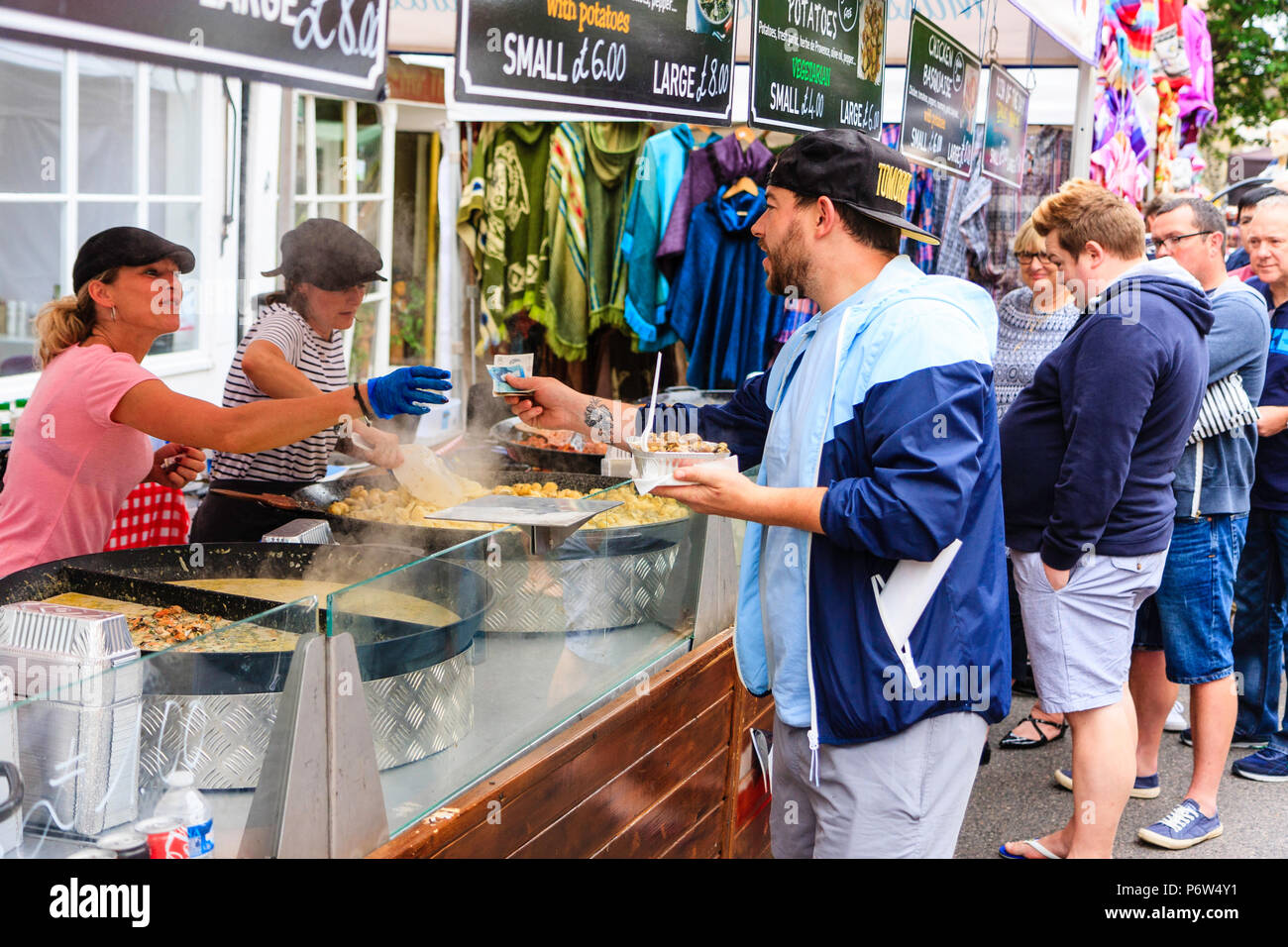 View along market stall selling hot food cooked in large cauldrons at ...