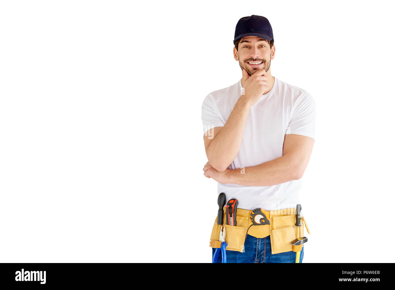 Portrait of happy young handyman wearing baseball cap and tool belt ...