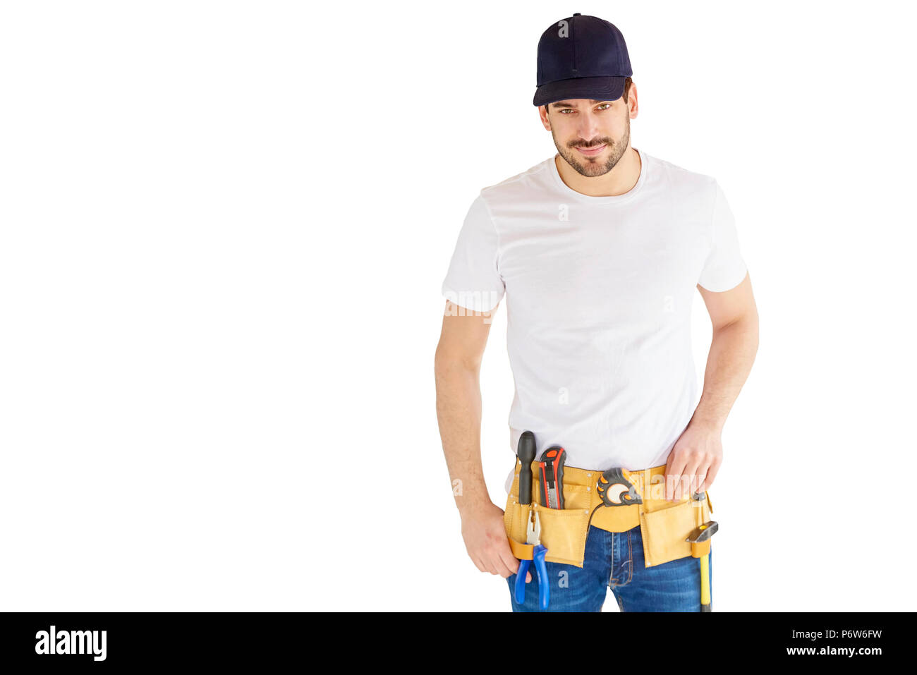 Portrait of handsome young handyman wearing baseball cap and tool belt ...