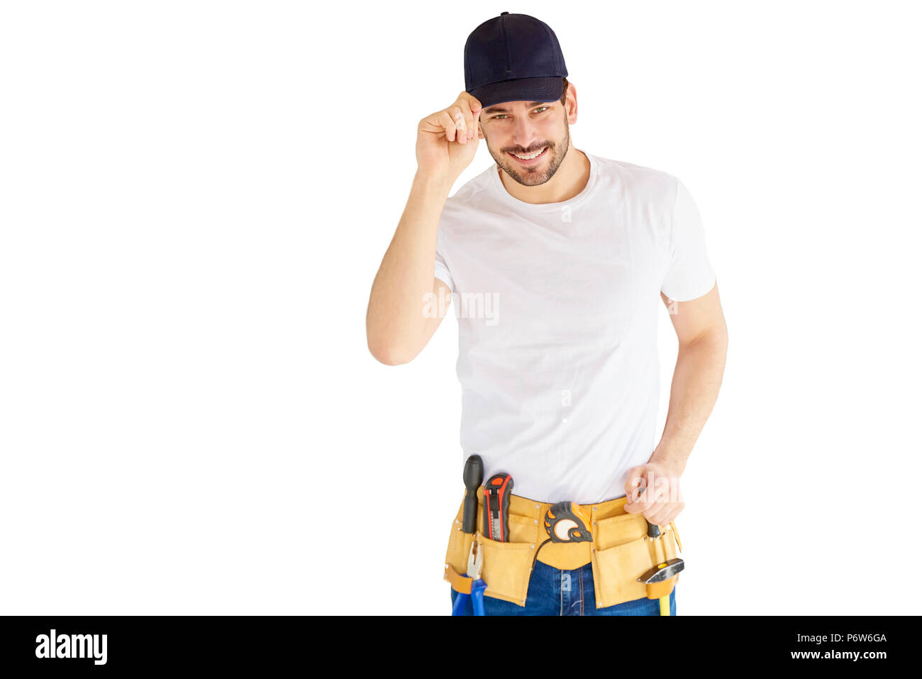 Portrait of handsome young handyman wearing baseball cap and tool belt ...