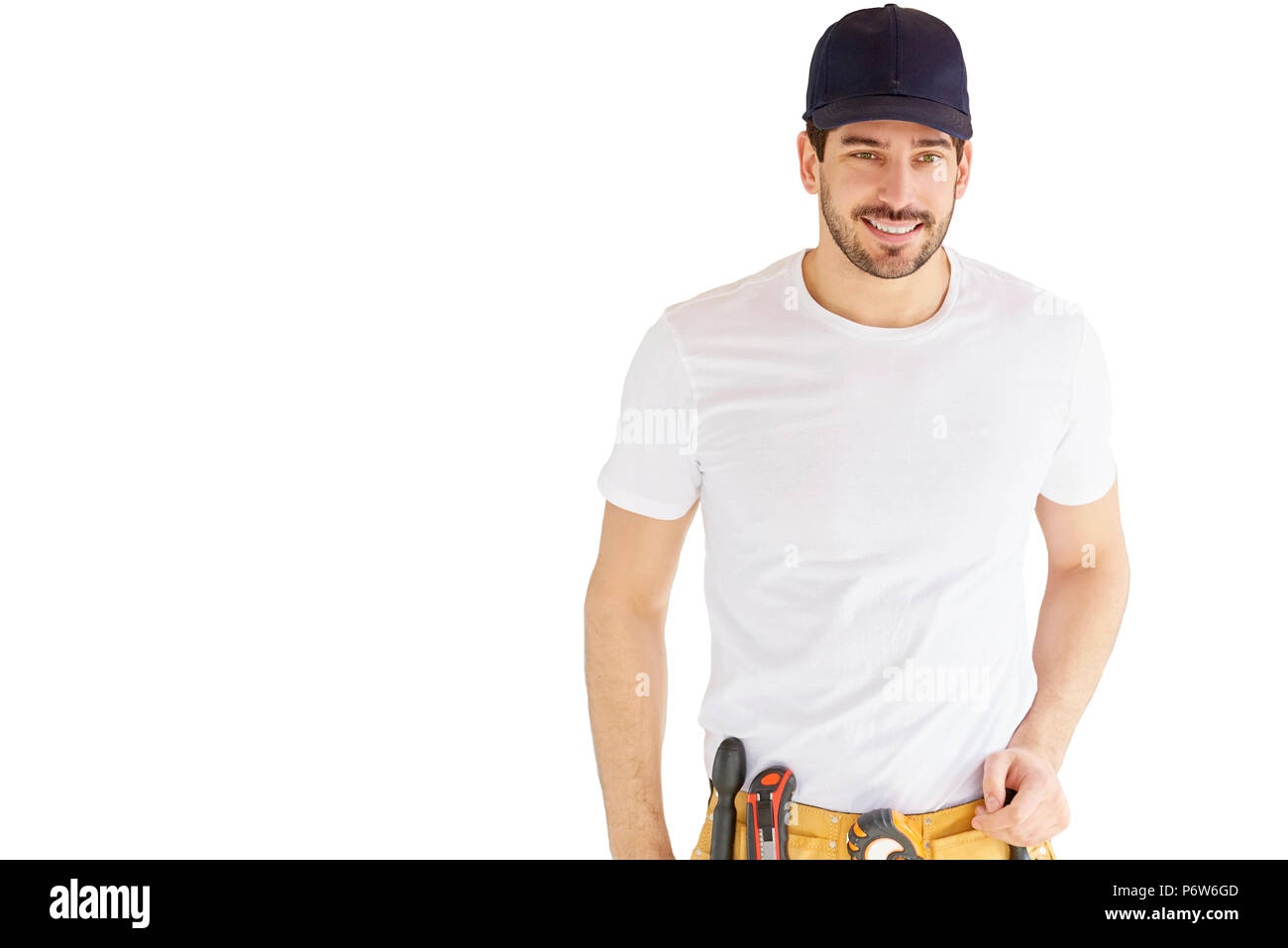 Portrait of handsome young handyman wearing baseball cap and tool belt ...