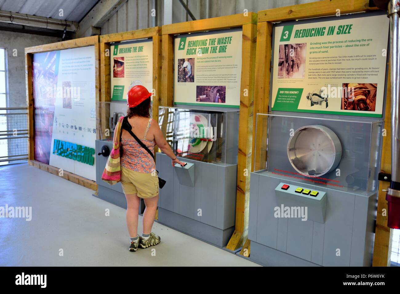 Tourist wearing red hard hat using interactive display,Geevor tin mine ...