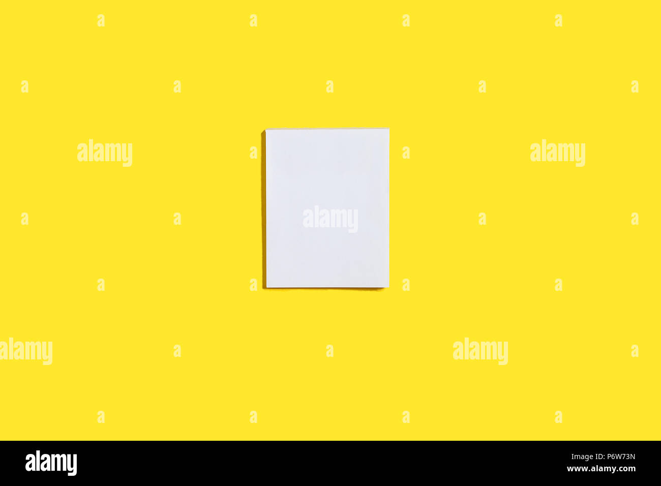 block of paper stickers on a yellow surface Stock Photo - Alamy