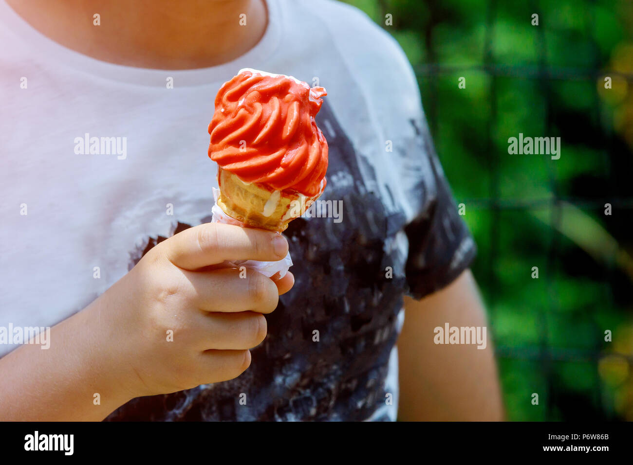 closeup of a young caucasian man with an ice cream cone in is hand ...