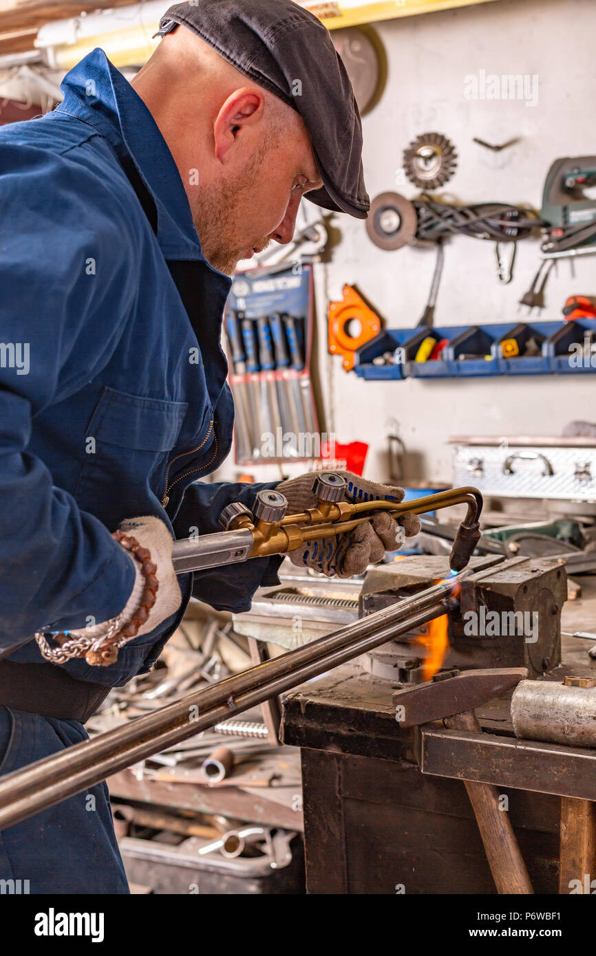 The young man, is going to cut a piece of metal autogenous welding ...