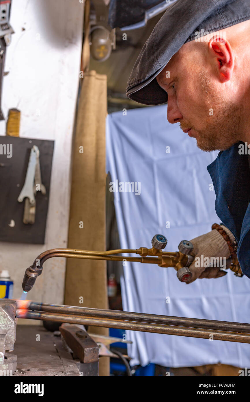 The young man, is going to cut a piece of metal autogenous welding ...