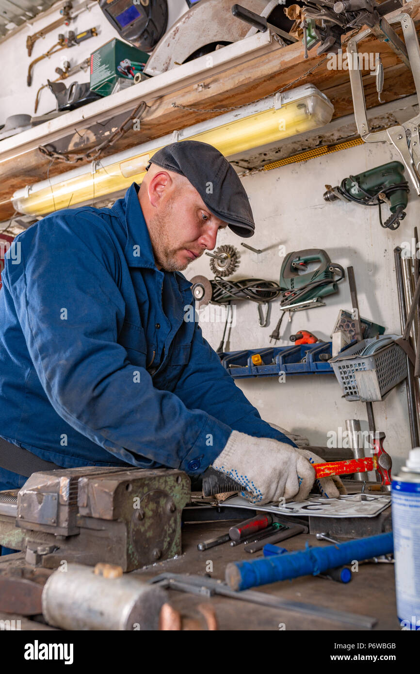 man hitting car license plate by hammer Stock Photo - Alamy