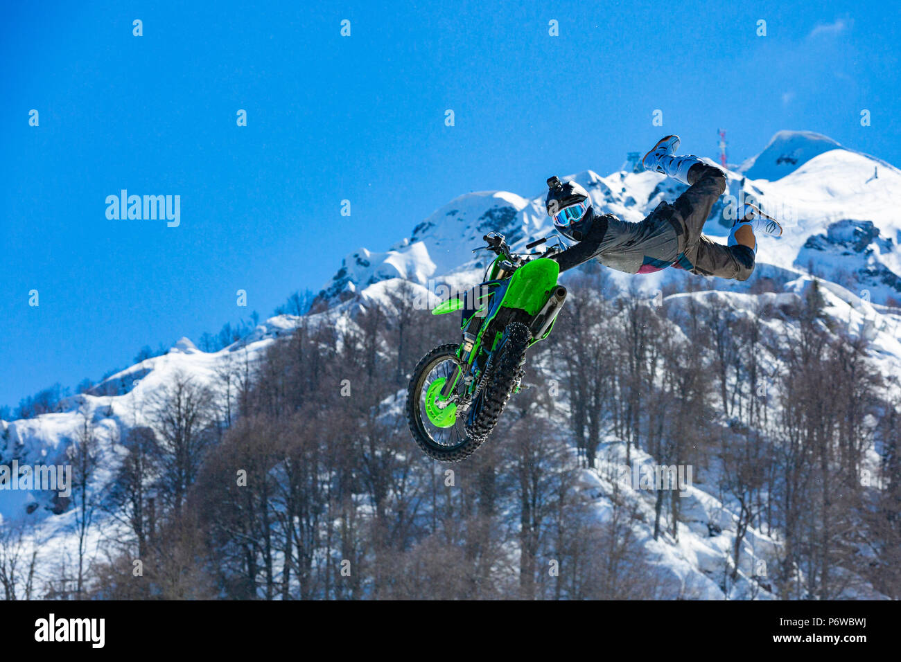 racer on a motorcycle in flight, jumps and takes off on a springboard ...